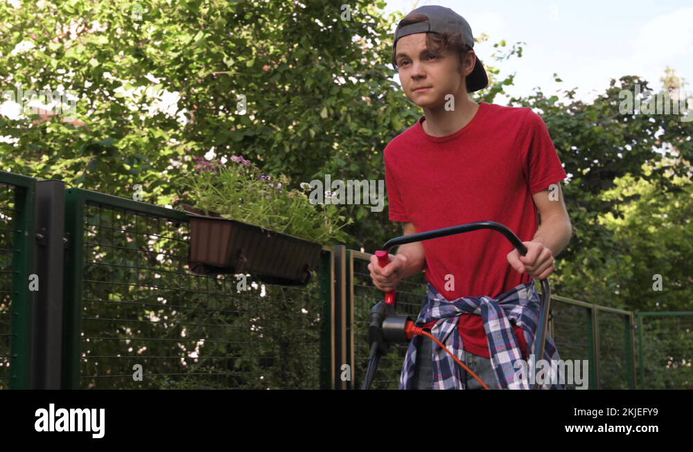 Boy cutting grass with lawn mower Stock Video Footage - Alamy