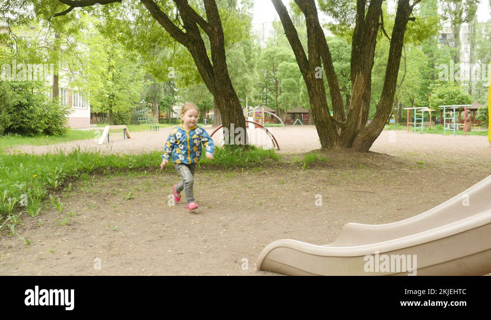 Little girl walking on playground. Kid walking and playing at ...