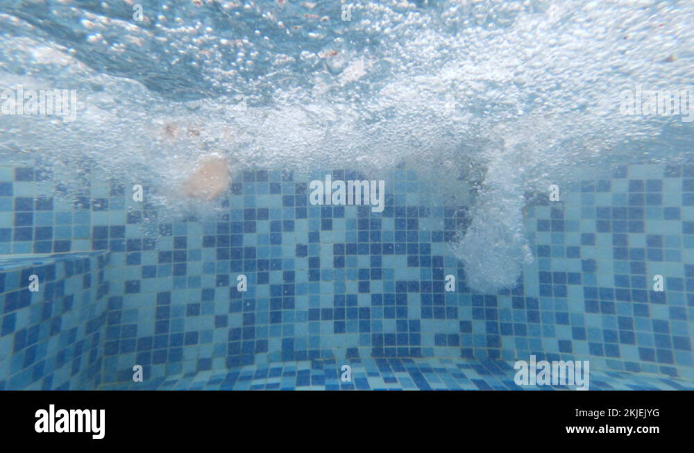 Underwater scene of child's legs splashing the water in the swimming ...