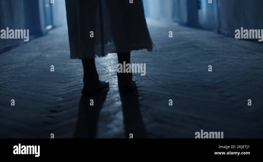 Low angle shot of legs of little girl ghost slowly creeping on floor of ...