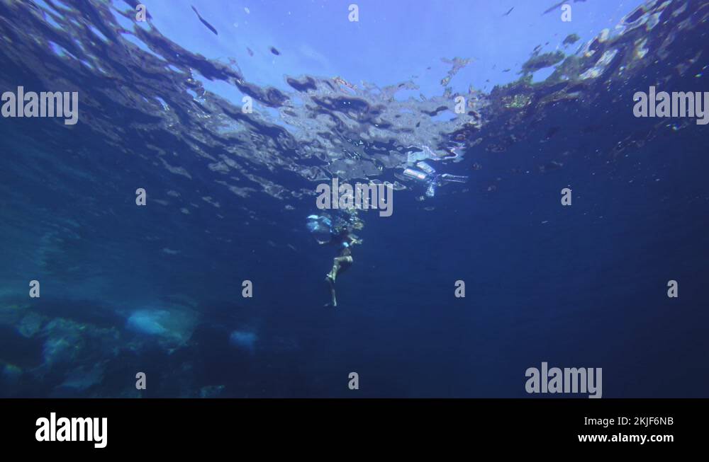 Underwater shoot of a dirty discarded plastic bottle floating in the ...
