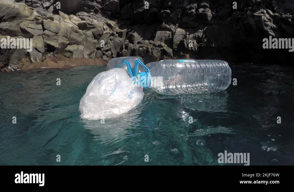 Underwater shoot of a dirty discarded plastic bottle floating in the ...