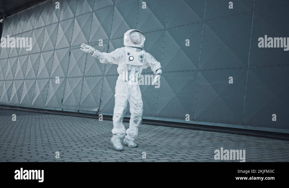 Handsome Man in Spacesuit is Dancing Next to Metal Wall. Astronaut is ...