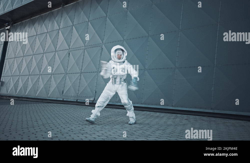 Handsome Man in Spacesuit is Dancing Next to Metal Wall. Astronaut is ...