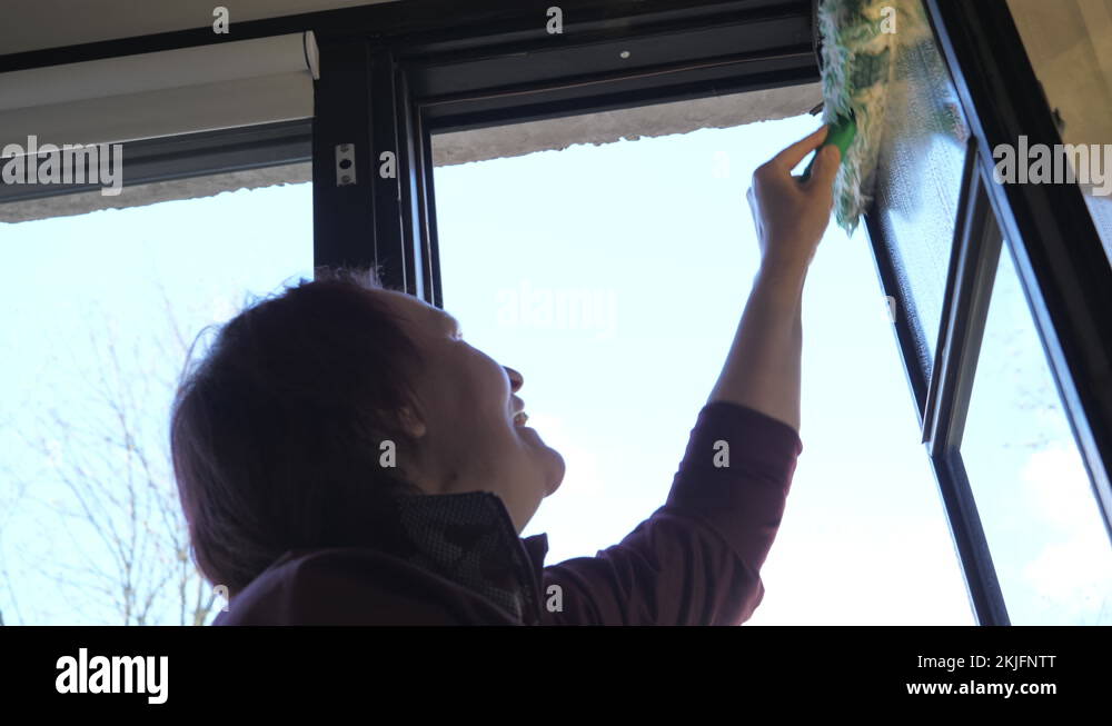 Closer look of the lady cleaning the glass window of the house Stock ...