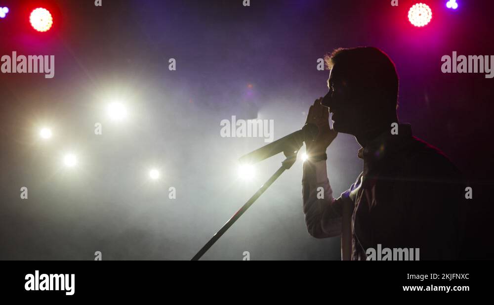Silhouette of man stand up comedian telling jokes in micropphone on ...