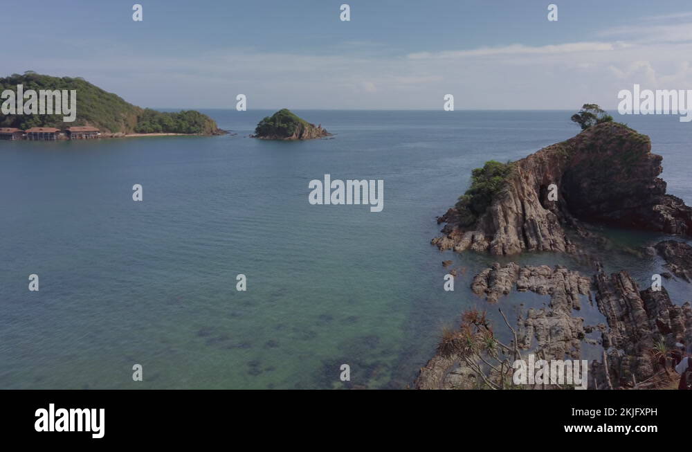Pan left from a small island islet towards holidays resorts on an ...