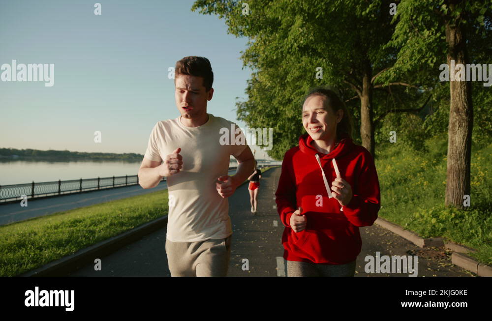 Three friends finishing the running distance. Two girls and one guy run ...