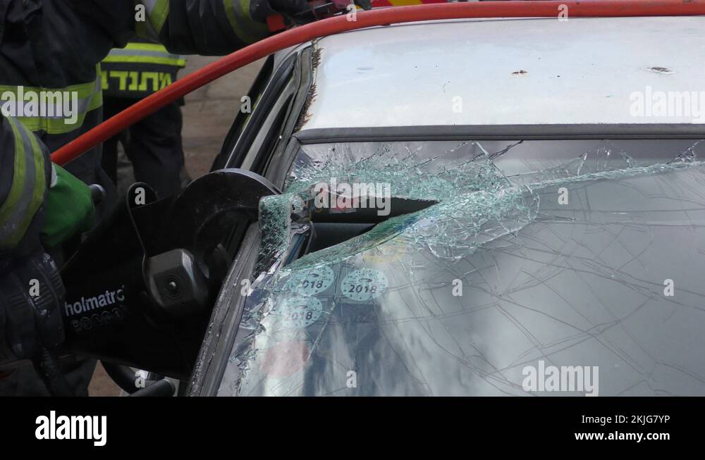 Firefighter opens door of car after accident with huge pneumatic plyers ...