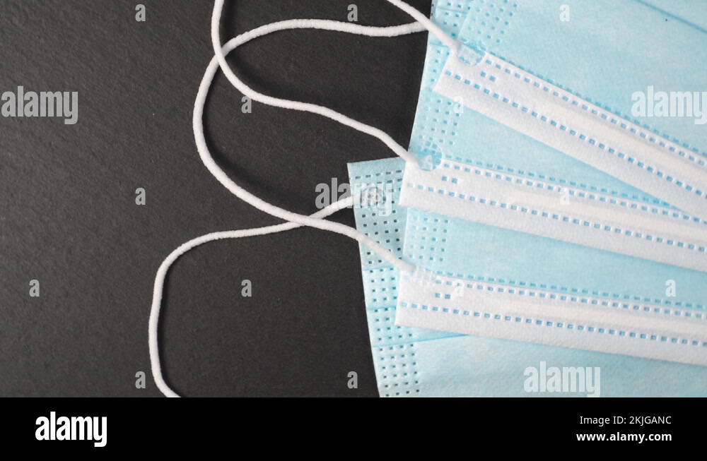 Medical disposable masks with rubber bands on a dark stone surface ...