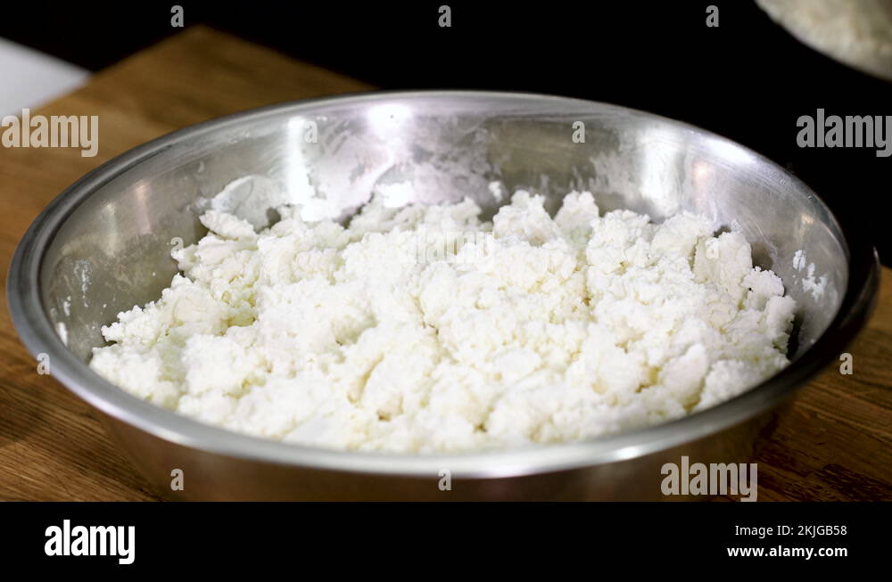 Chef pouring mixture of the egg yolks and butter into a bowl with curd ...