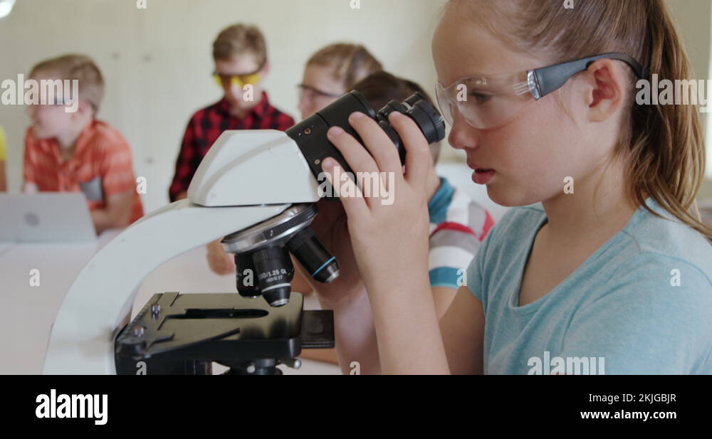 Girl wearing glasses using microscope Stock Video Footage - Alamy