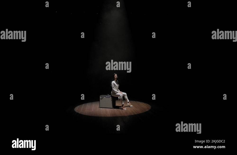 A young beautiful female singer poses on stage in the dark Stock Video ...