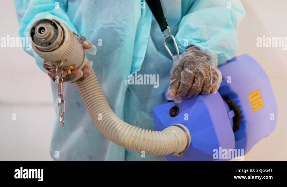 Medical worker holding sanitizing machine, Ultra Low Volume fogging ...