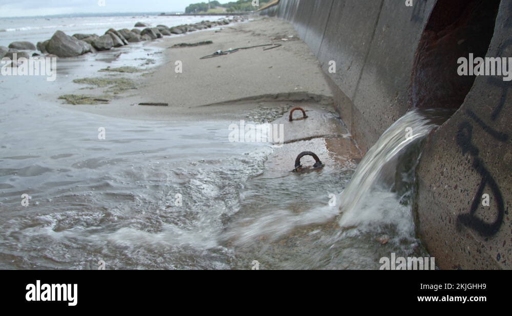 Wastewater from sewer drain pipe flowing into sea water environment ...