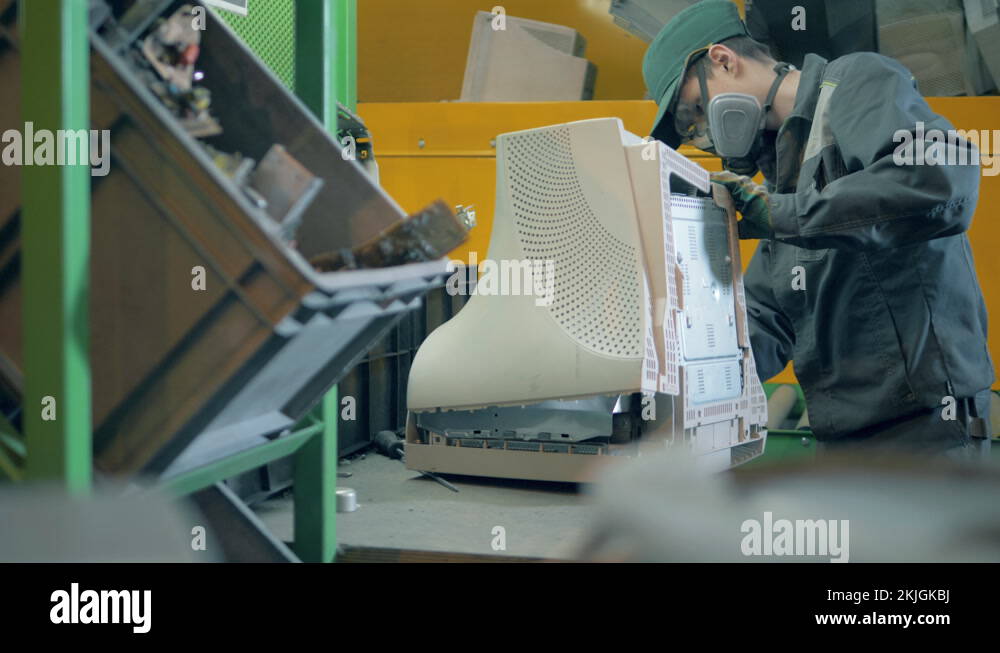 Trash, e-waste, electronic garbage recycling factory. A person takes ...