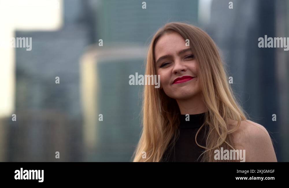 beautiful lady is singing song in city, standing at roof, skyscrapers ...