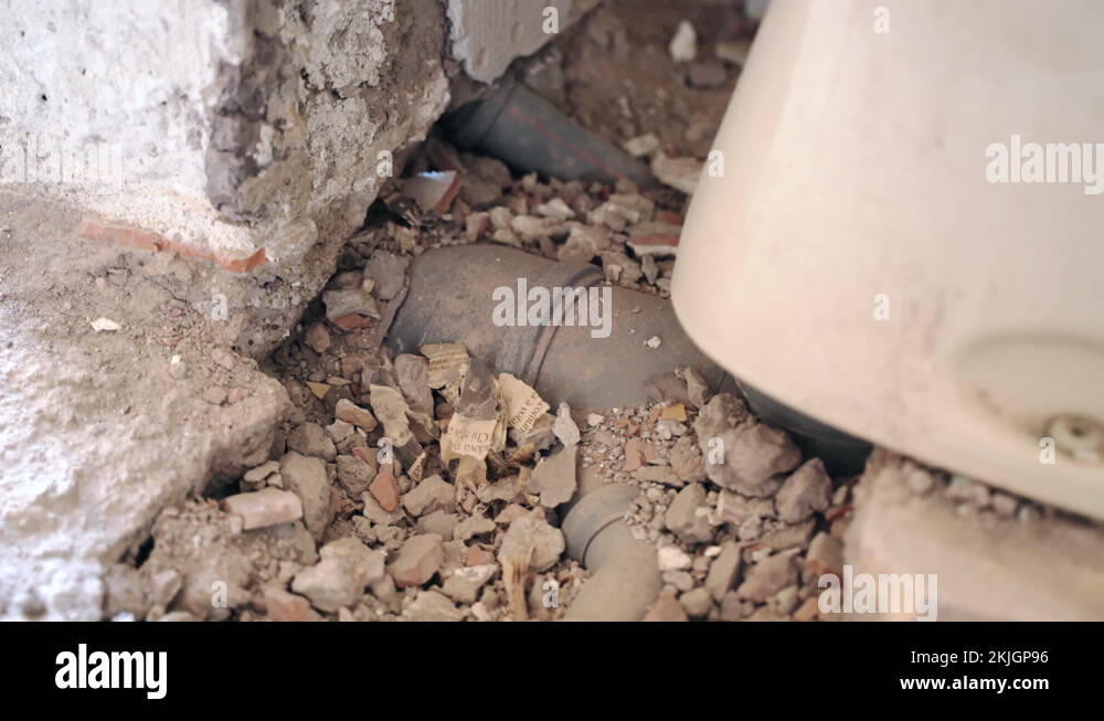 Close-up of hidden plastic sewerage pipe under the rusty toilet on ...