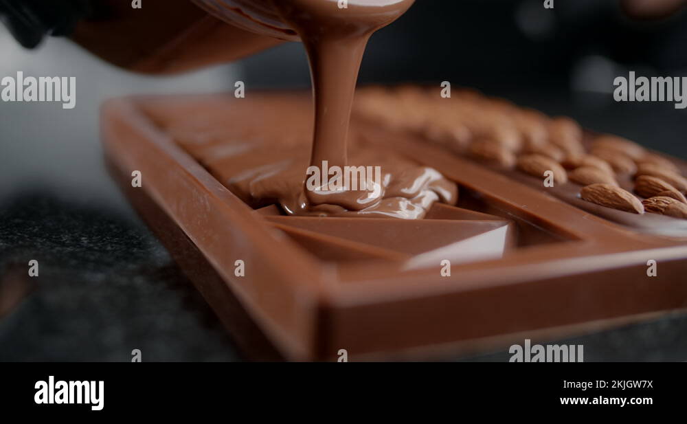 Chef confectioner makes chocolate bar - he pours hot melted chocolate ...