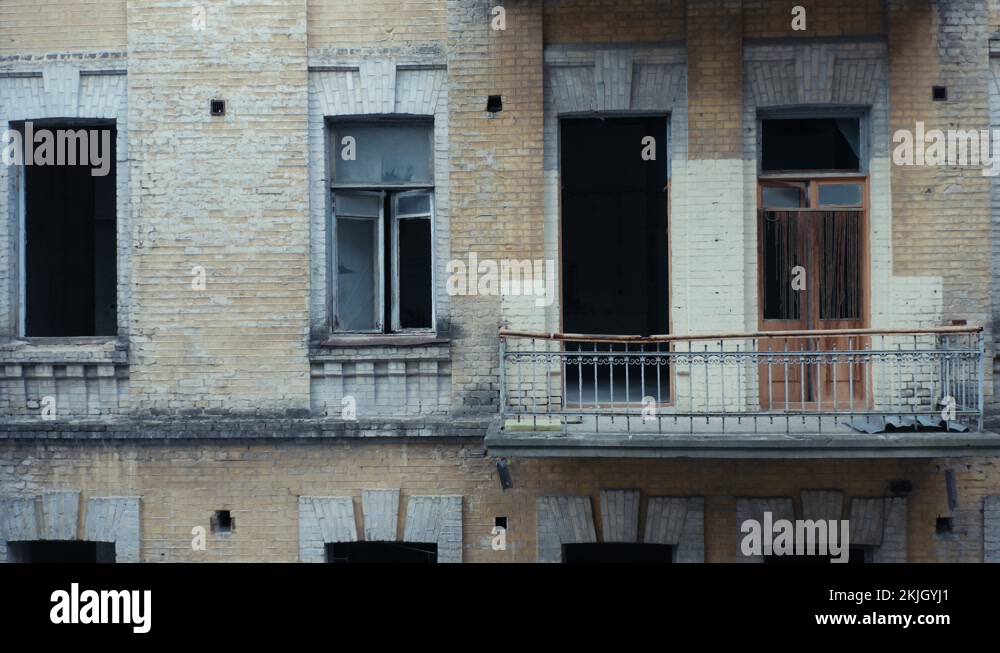 Broken windows in an abandoned 19th century apartment building with a ...