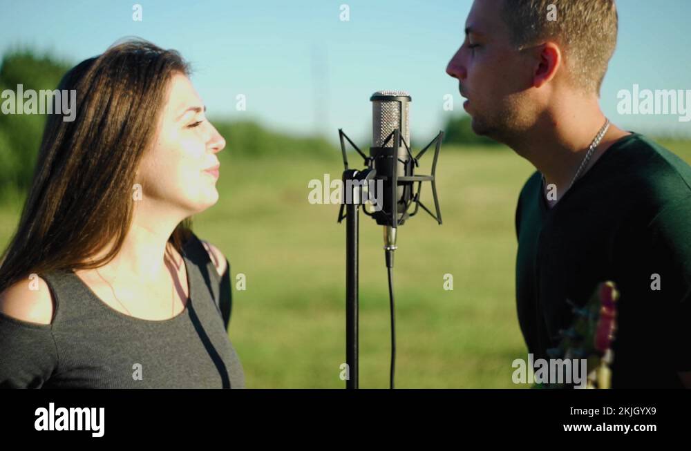 Two lovers sing an energetic song into the microphone. Cool shots in ...