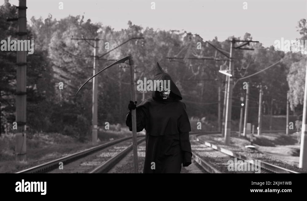 Scary Grim Reaper Walking on the Railway Tracks Stock Video Footage - Alamy
