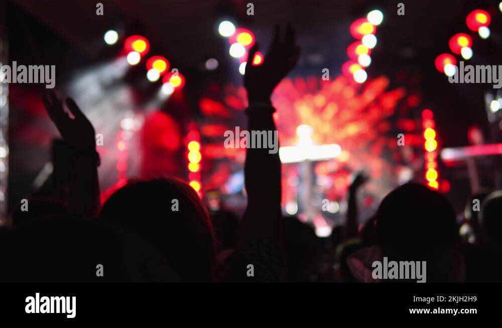 Happy people dance in party concert and listen to music from the stage ...