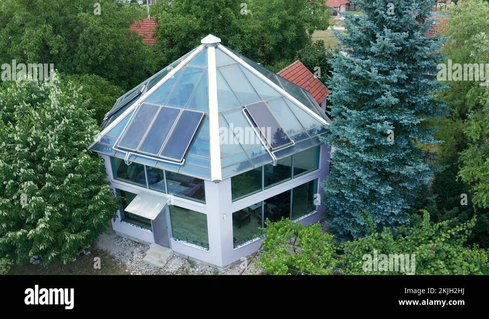 Glass roof with panels and transparent walls of solar house with ...