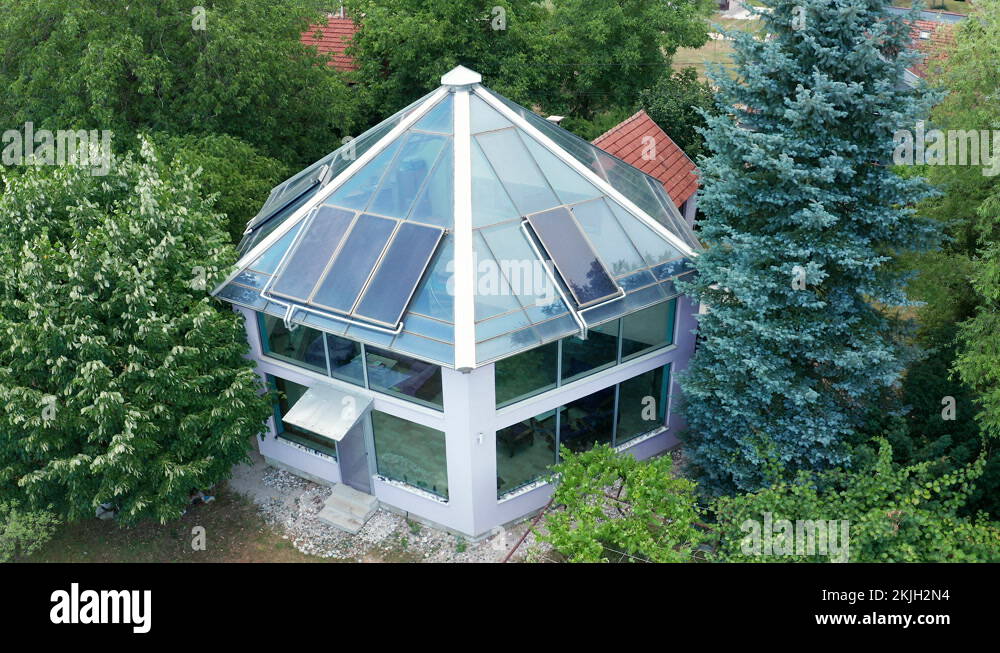 Glass roof with panels and transparent walls of solar house with ...