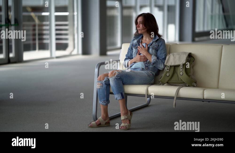 tired woman is waiting boarding in airport or station, sitting on chair in Stock Video Footage ...