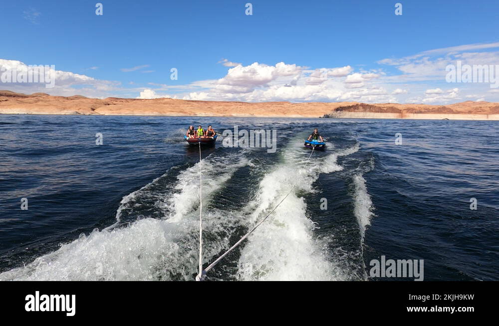 Family riding float tubes behind fast boat Lake Powell Utah 4K Stock ...