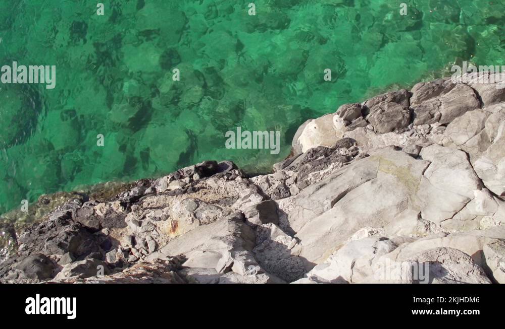 Pov looking down cliff at greenish blue water in Maui Hawaii Stock ...