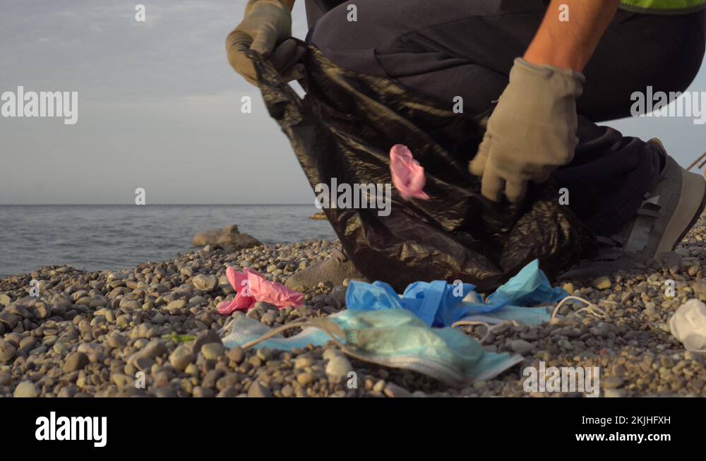 Used disposable masks and gloves thrown out by the waves. Pollution of ...