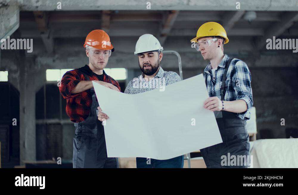 Group of construction engineers are looking at the plan of the facility ...