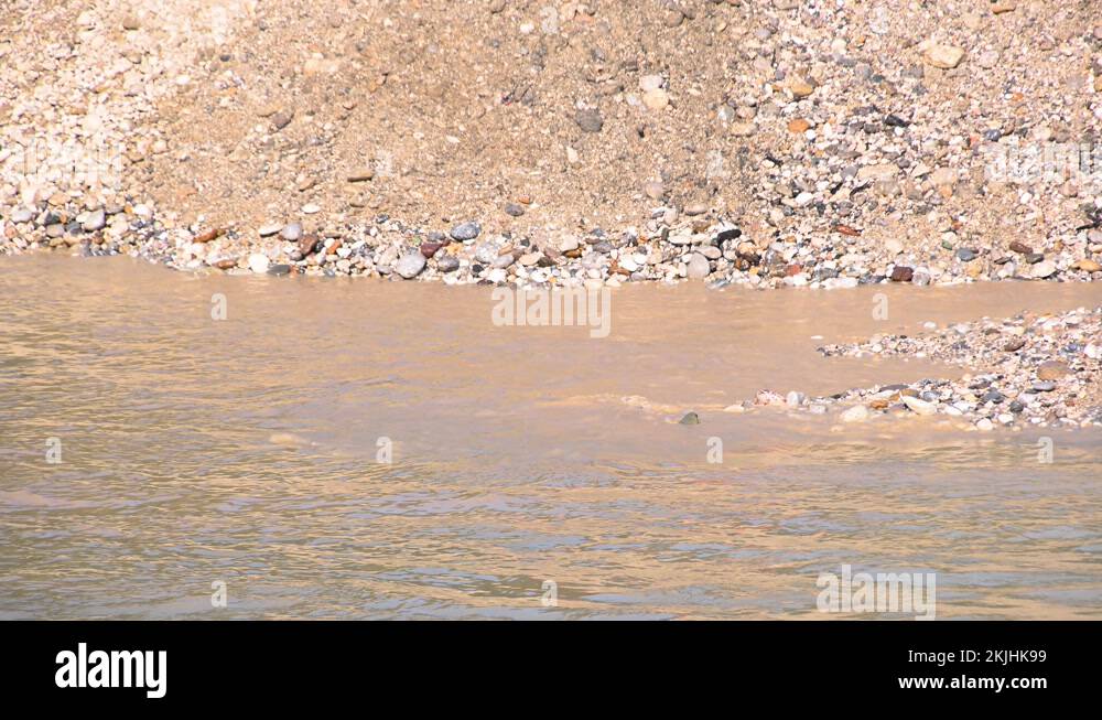 Excavator bucket close up. Excavator digging river rocks sand and ...