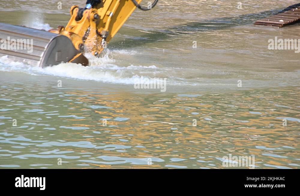 Excavator bucket close up. Excavator digging river rocks sand and ...