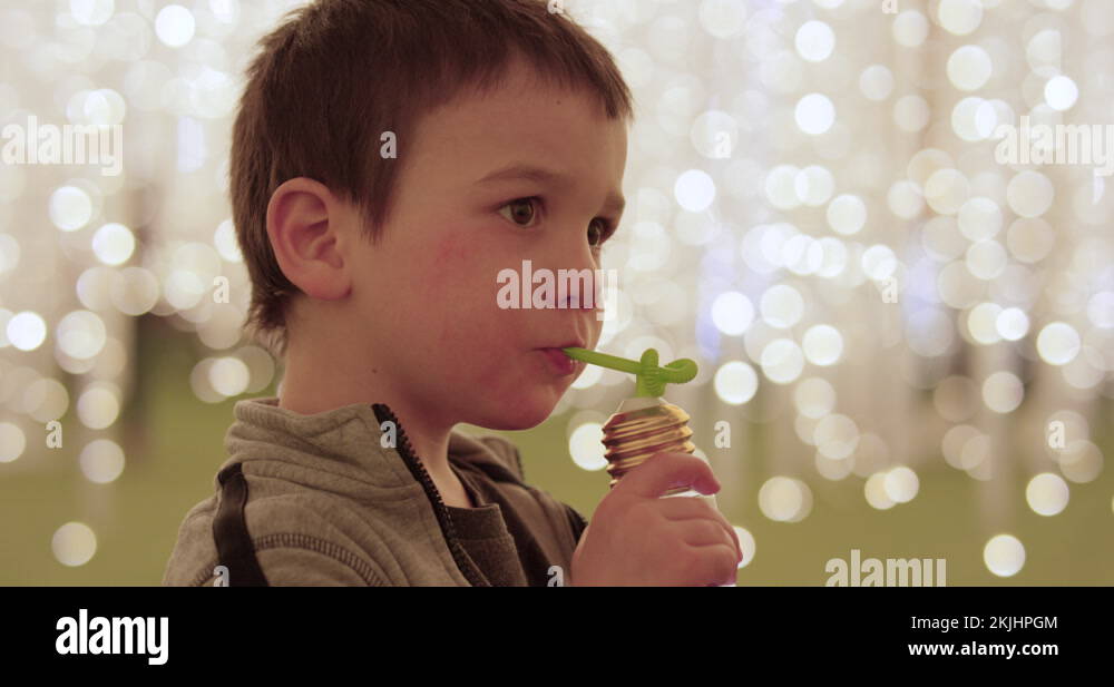Toddler boy sipping drink from bendy straw at light show - close up on ...