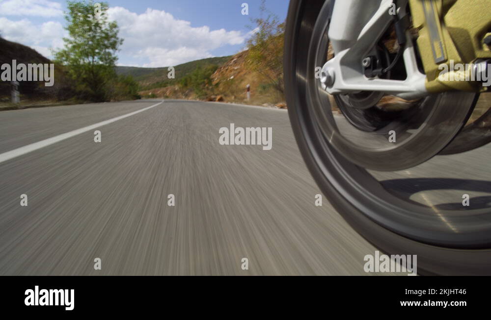 Motorcycle ridind on a road in nature. Close up wheel on a bumpy ...
