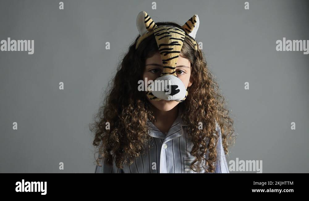 Young girl wearing tiger mask, roaring Stock Video Footage - Alamy