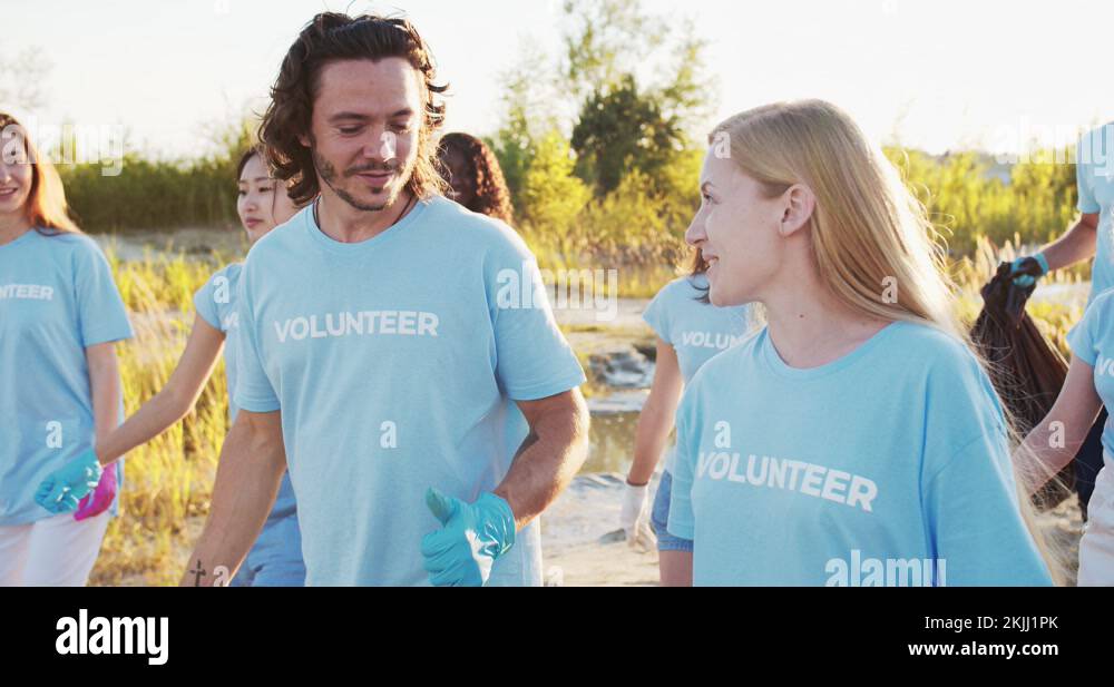 A group of volunteers of different ages finishing work and going home ...