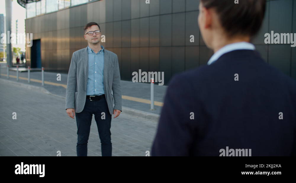 Two managers, a man and a woman, meet on the street against the ...