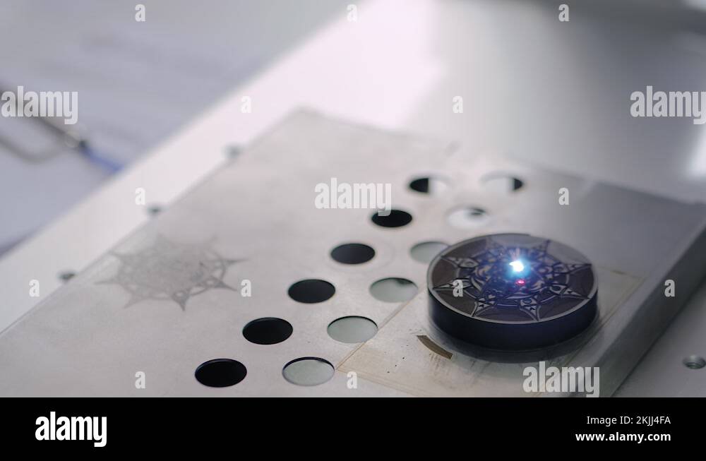Laser engraving machine burning sign of star on circular plastic ...