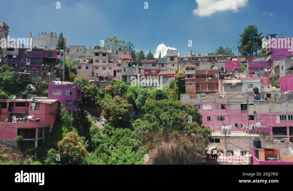 Pink low-income houses. Vibrant favelas with Mexico city skyline on a ...