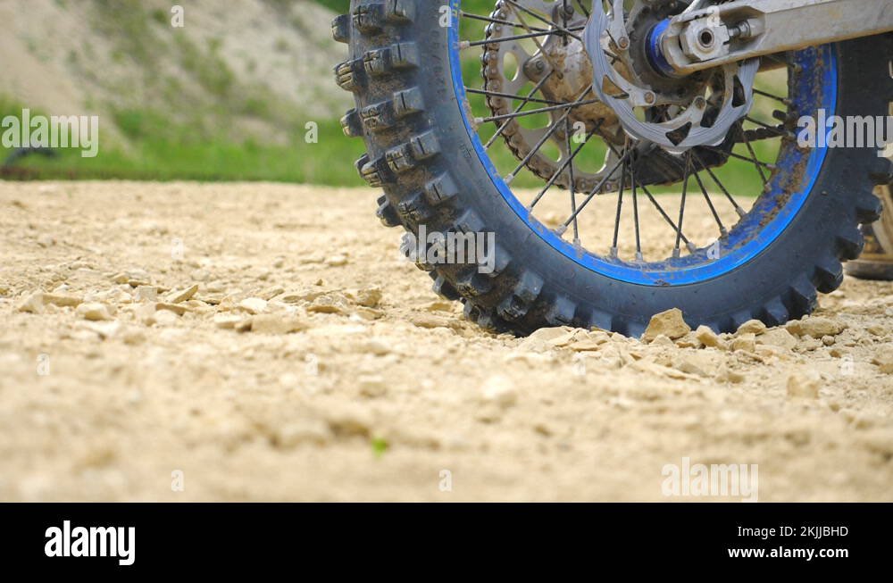 Close up wheel of powerful off-road motorcycle spinning and kicking up ...