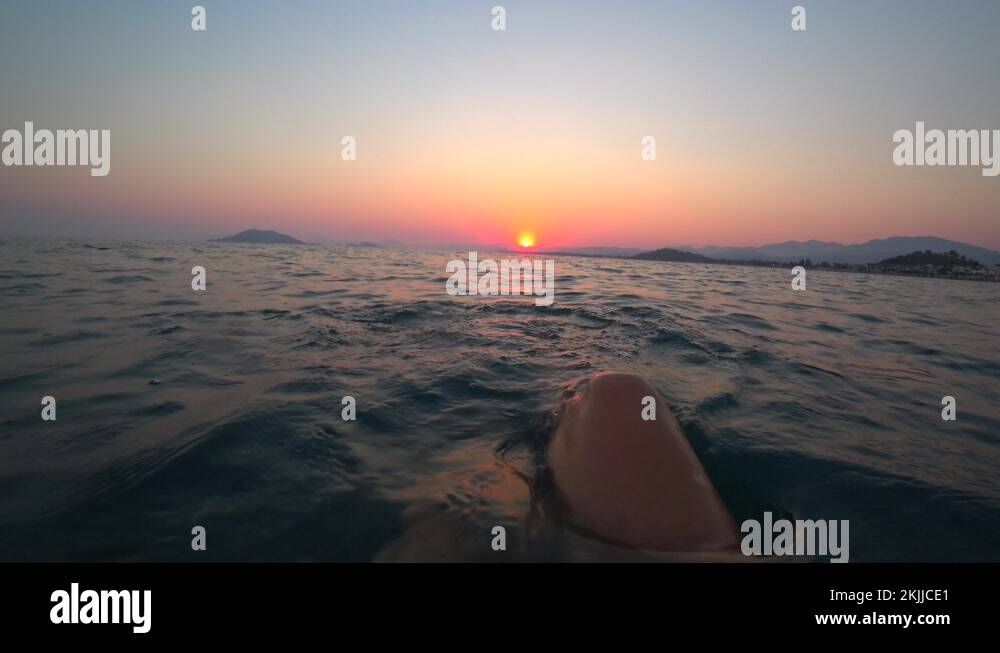 Female legs slowly moving while swimming on back against the declining ...