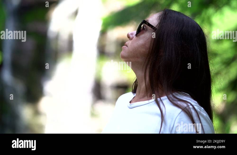 tourist woman is breathing fresh air in tropical forest with waterfall ...