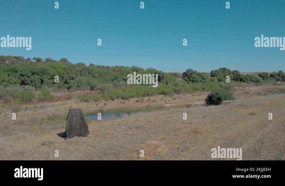 Portable hunting photo hide covered with camouflage net in an open ...