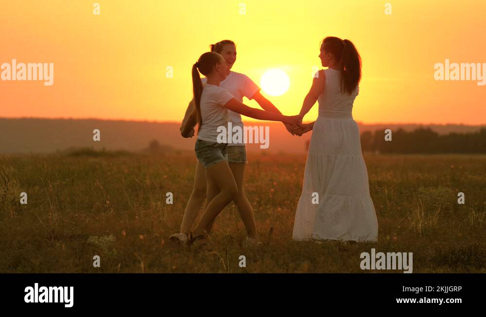 young mother with healthy daughters and sisters dance together in a ...