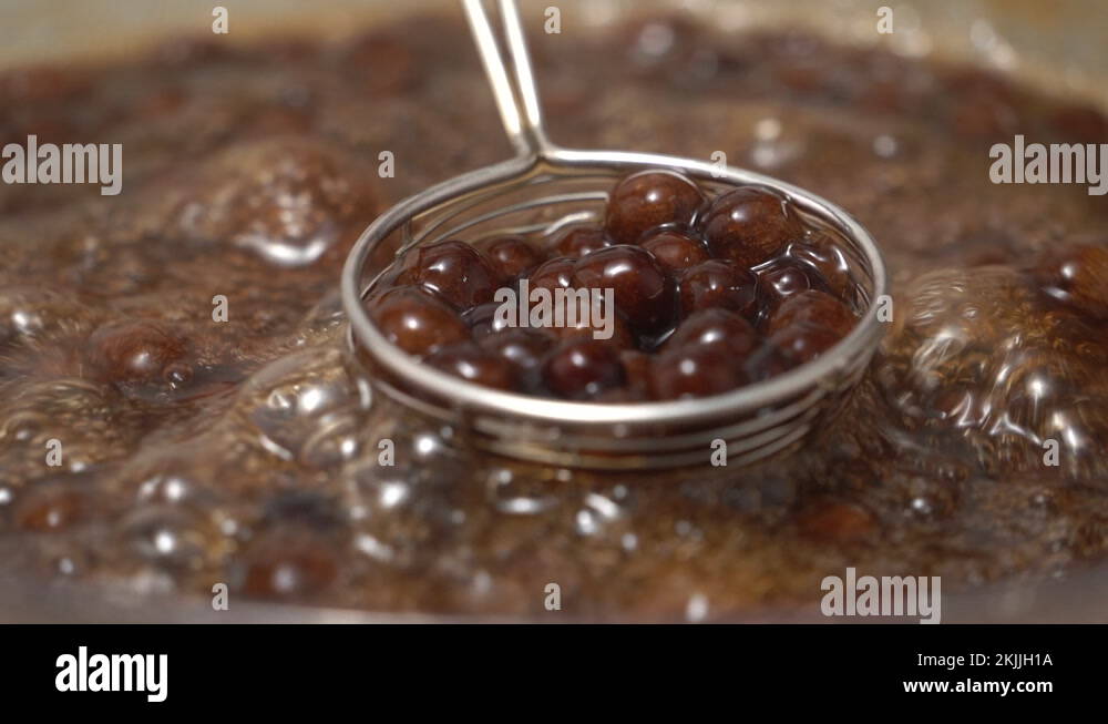 Cooking, boiling brown sugar flavor tapioca pearl balls, close up Stock ...