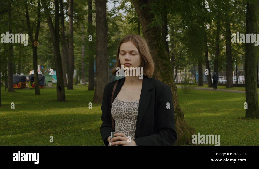 Girl shoots with a vintage movie camera around herself in a park Stock ...